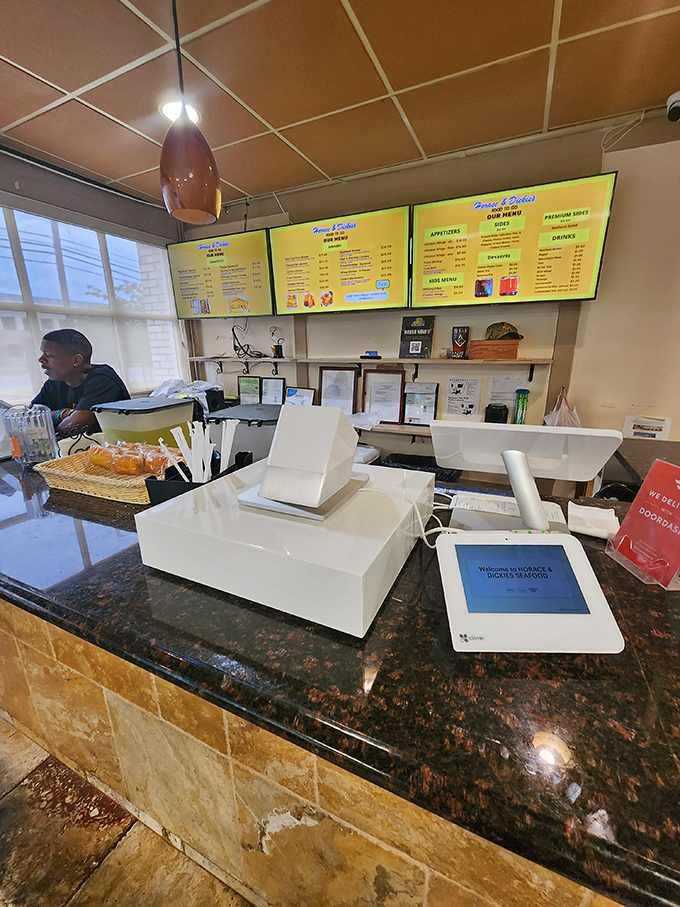 The command center – where digital meets delicious. Behind that counter, seafood magic happens with methodical precision.