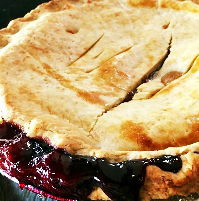 This berry pie isn't just leaking—it's showing off. The crimson filling escaping its buttery prison is nature's way of saying "eat me now."
