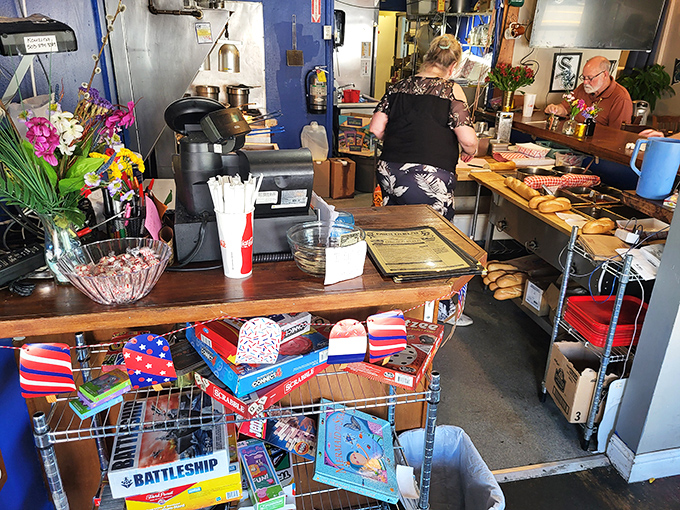 Behind every great sandwich is a kitchen where the magic happens. Board games stacked below remind you this place feels like home.
