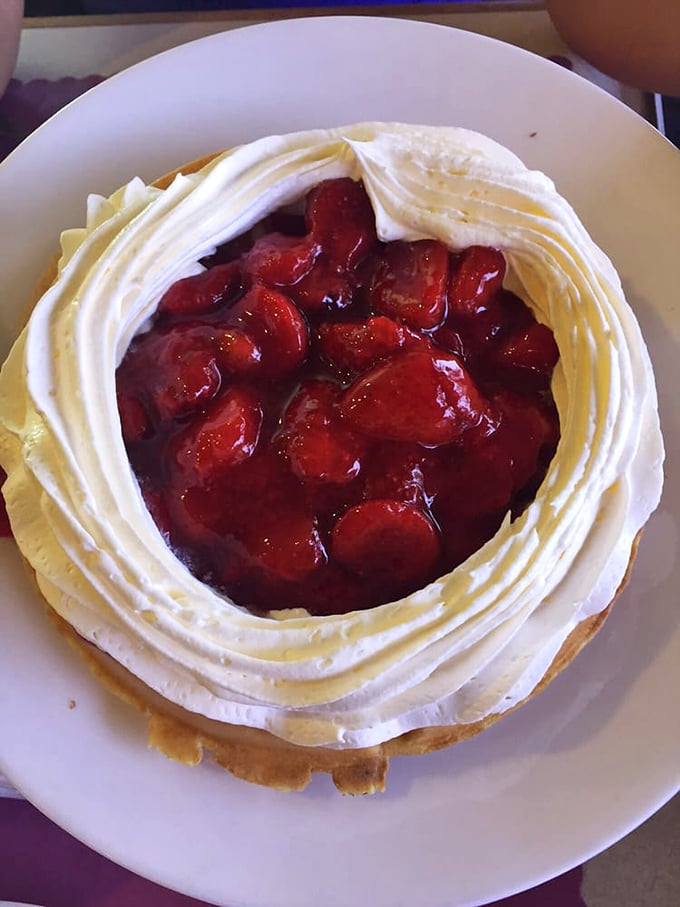 This isn't just a Belgian waffle—it's a stage for strawberry drama. That ring of whipped cream contains summer's sweetest berries in their syrupy glory.
