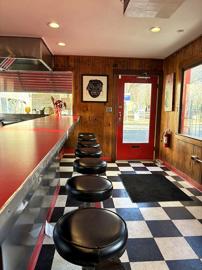 The entrance to burger paradise—complete with classic checkerboard floor and warm wooden walls that whisper "come in, get comfortable."