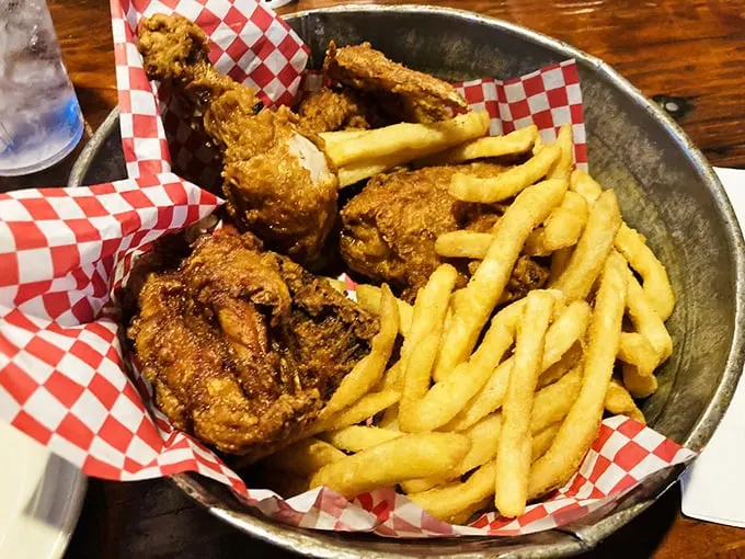 Fried chicken with a crust so audibly crunchy it deserves its own microphone, nestled alongside fries in a metal basket of joy.