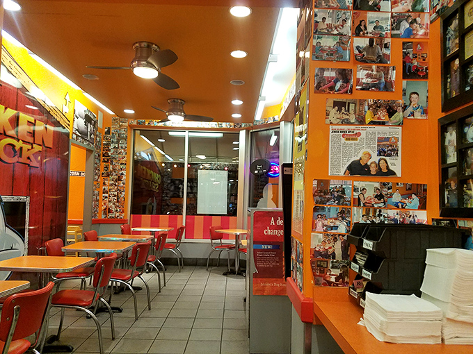 Customer photos line the vibrant orange walls – a hall of fame celebrating those who've accepted the delicious challenge.