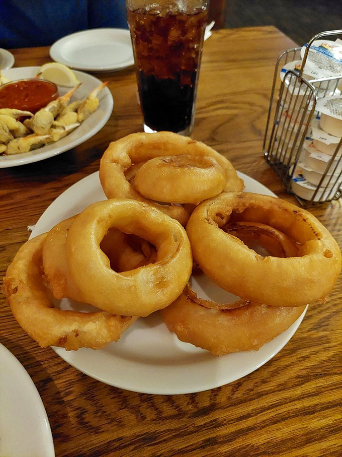 Onion rings stacked like delicious golden halos. These aren't just a side dish—they're crispy, sweet-savory circles of happiness that deserve their own moment in the spotlight.