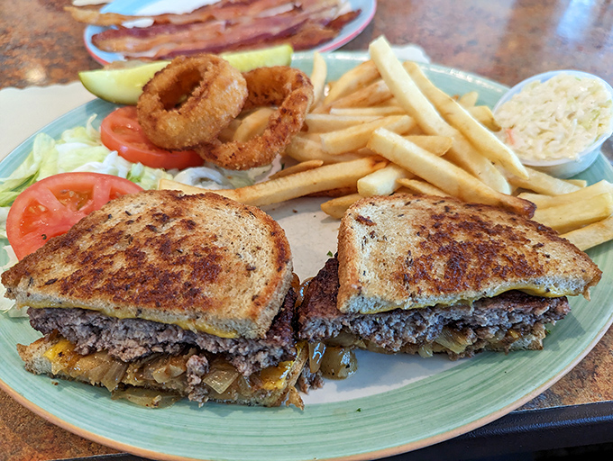 This isn't just a sandwich—it's a masterclass in the art of comfort food, complete with crispy fries and onion rings that deserve their own fan club.