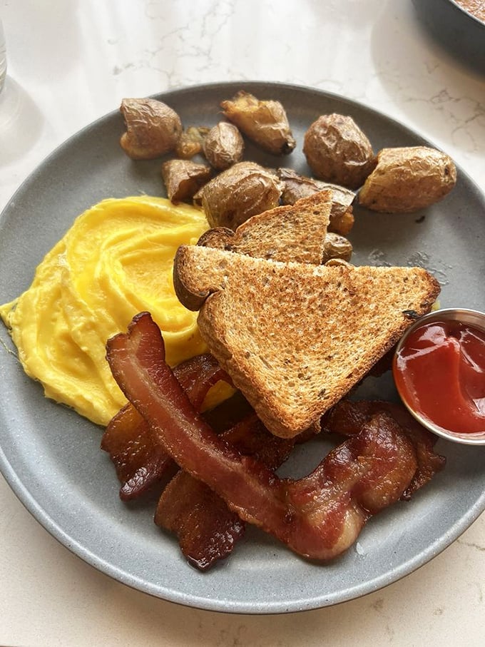 Breakfast that doesn't whisper "good morning" but instead delivers a warm, buttery hug with bacon exclamation points.