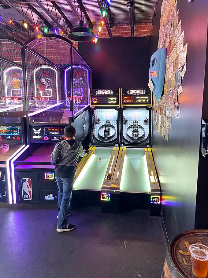 Skee-ball mastery in progress – this young competitor demonstrates perfect form while embracing the timeless joy of arcade gaming.