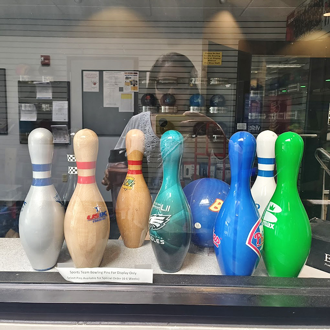 Sports team bowling pins stand at attention in their display case, like tiny ambassadors from Philadelphia's athletic universe.