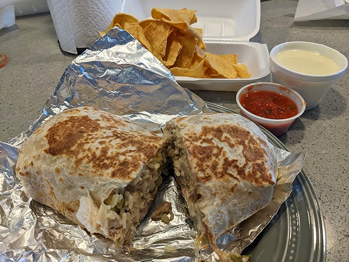This burrito cross-section reveals the careful architecture within—layers of flavor that would make Frank Lloyd Wright weep with joy.
