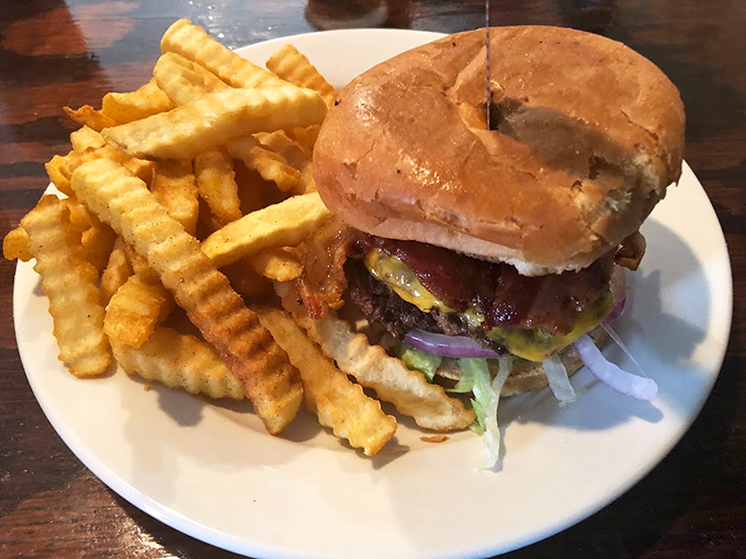 The burger arrives looking like it just stepped off a commercial set—the kind that makes neighboring tables ask, "What is THAT and how do I get one?"