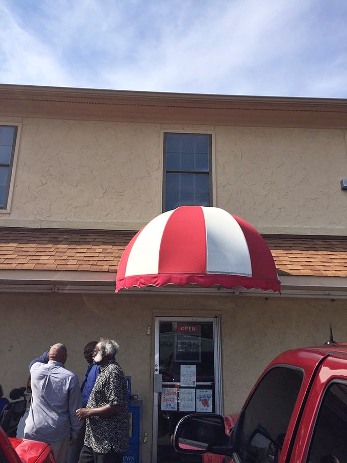 The red and white awning signals you've arrived at your destination. The line of waiting diners confirms you've chosen wisely.