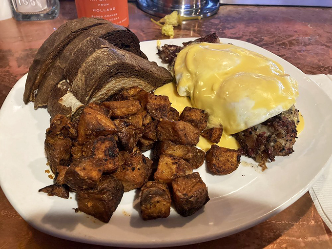 The Goat Hash Special in all its glory—crispy potatoes, savory meat, and hollandaise that flows like a yellow river of dreams.