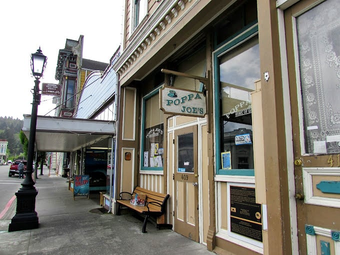 Poppa Joe's storefront maintains its vintage charm with a simple bench inviting passersby to sit a spell—small-town hospitality in architectural form.
