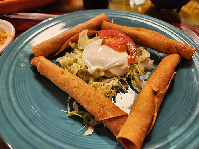 These taquitos aren't just rolled tortillas—they're crispy cylinders of joy standing guard around a fresh salad center. Crunchy sentinels of satisfaction.
