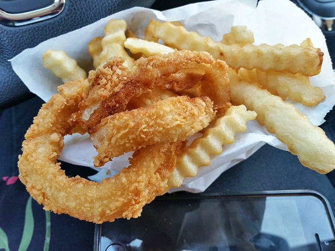 Golden onion rings that shatter at first bite, paired with crinkle-cut fries—a perfect marriage of texture that makes you forget vegetables ever grew in dirt.