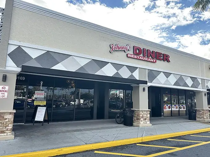 Johnny's Diner exterior beckons with its classic black and white diamond pattern – like a chess board where every move leads to delicious victory.