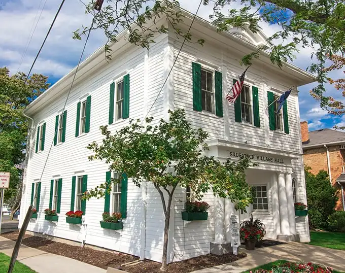 The Saugatuck Village Hall stands proudly with its crisp white clapboard and green shutters—like the community's living room dressed in its Sunday best.