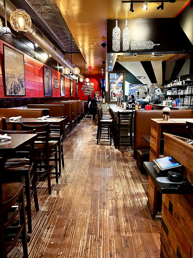 Industrial-chic meets comfort food haven—red walls, wooden booths, and lighting that's just dim enough to forgive your burger-induced food coma.