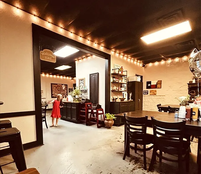 String lights cast a warm glow over simple tables where barbecue dreams come true. This isn't ambiance by design—it's ambiance by deliciousness.