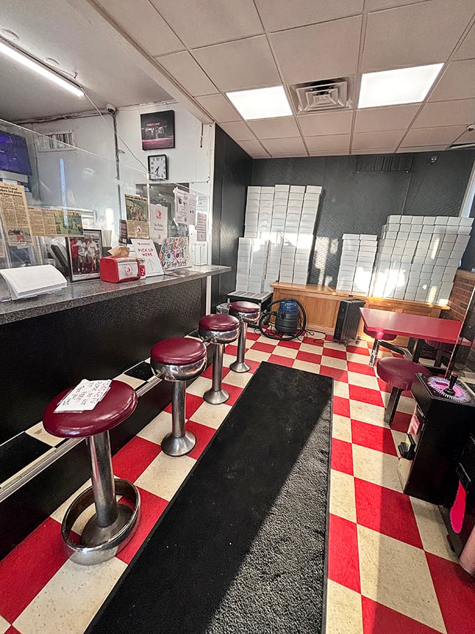 Looks like someone hit the retro jackpot—red vinyl stools, checkerboard floors, and enough boxes to stage a carb-fueled Broadway show.