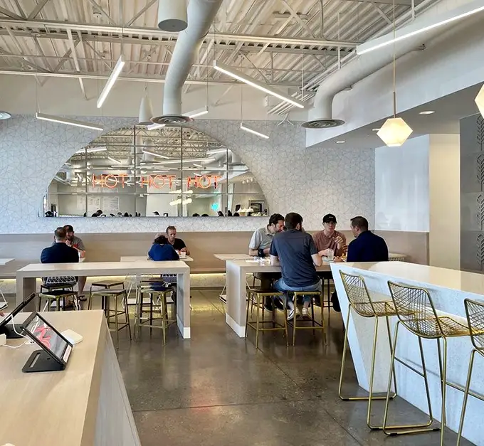 Modern, airy interiors with geometric patterns and communal seating create the perfect backdrop for chicken-induced euphoria. The "HOT CHICKEN" sign isn't just decor—it's a promise.