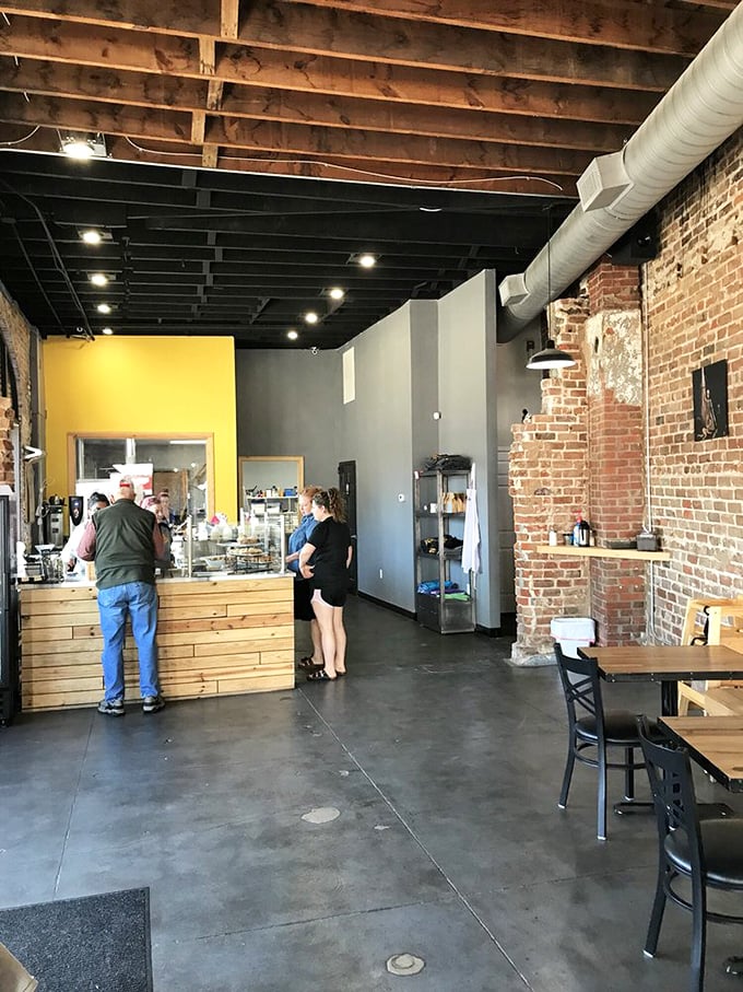 Industrial-chic meets bakery warmth with exposed brick walls, wooden beams, and concrete floors – the perfect backdrop for sugar-induced euphoria.
