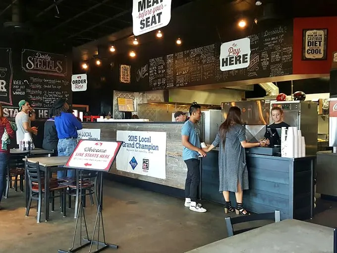 Industrial chic meets barbecue philosophy on this statement wall. The restaurant's manifesto reminds you this isn't their first rodeo at the smoker.