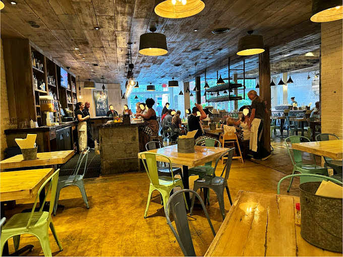 Inside, industrial-chic meets seaside nostalgia with concrete ceilings and colorful metal chairs – proof that great seafood doesn't require ocean views, just serious culinary commitment.