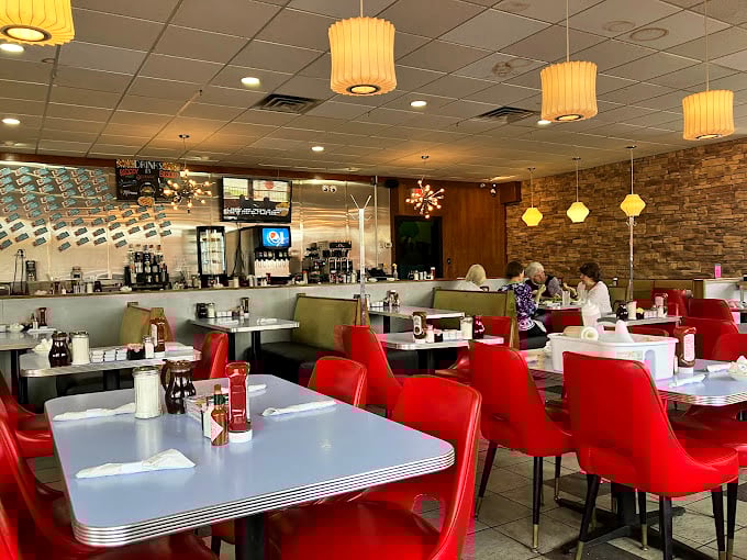 Red chairs that pop like exclamation points against the warm stone wall. This isn't just a diner—it's Delaware's living room.