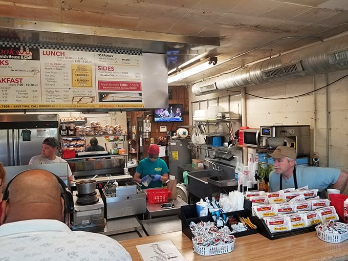 Behind the counter, culinary choreography unfolds as burgers sizzle and orders fly in this cash-only kingdom of comfort food.