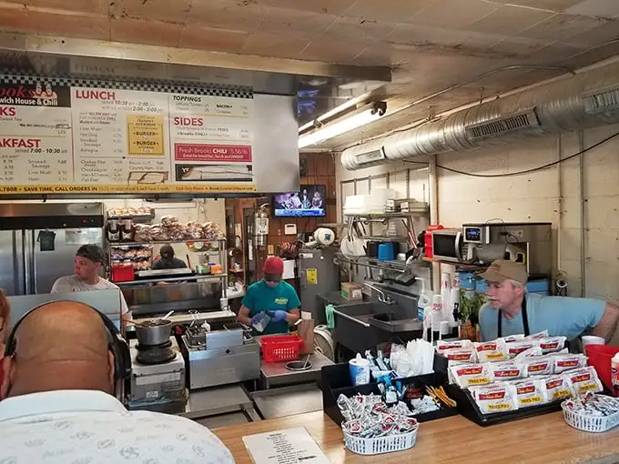 Behind the counter, culinary choreography unfolds as burgers sizzle and orders fly in this cash-only kingdom of comfort food.