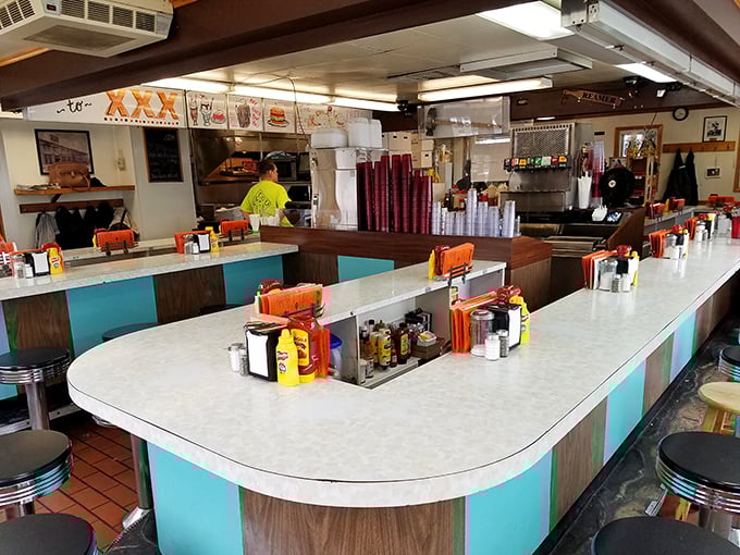 The horseshoe counter isn't retro-chic by design—it's authentic by longevity. Where strangers become friends over shared condiment caddies and burger anticipation.