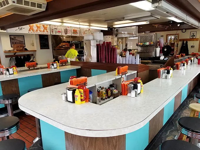 The horseshoe counter isn't retro-chic by design—it's authentic by longevity. Where strangers become friends over shared condiment caddies and burger anticipation.