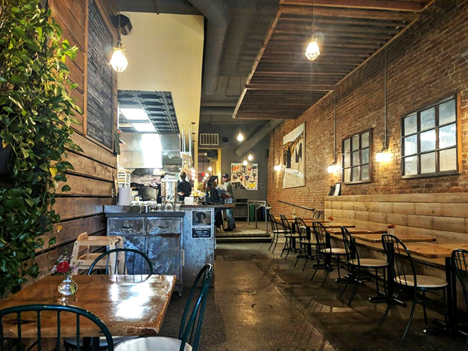 Edison bulbs cast a warm glow over wooden tables where food dreams come true. The exposed brick walls aren't trying to impress—they're just being authentically themselves. 