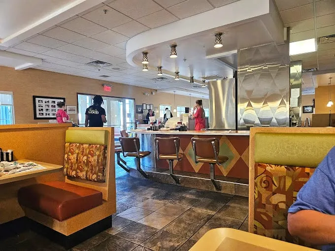 Classic diner geometry at its finest—where counter seating meets cozy booths, and the gentle hum of conversation blends with the sizzle from the kitchen.
