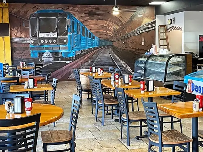 Step into a New York subway fantasy complete with a blue train eternally arriving at the station. The mural transforms lunch into a Manhattan commute—minus the delays.