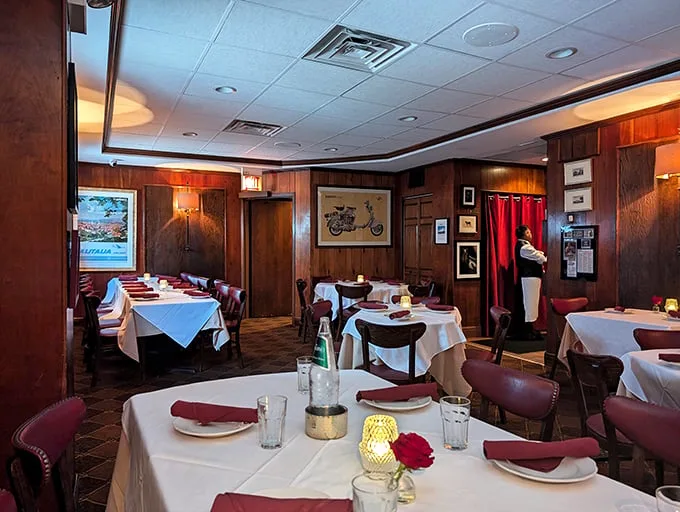 Wood-paneled walls tell stories older than most marriages. White tablecloths and burgundy napkins set the stage for serious dining business.
