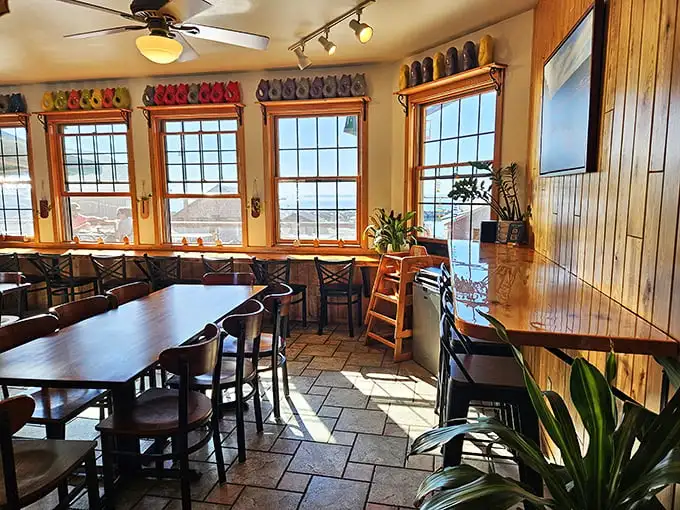 Sunlight streams through windows framing Lake Superior views, turning this cozy dining room into the world's most delicious fishbowl—except you're the one doing the eating.