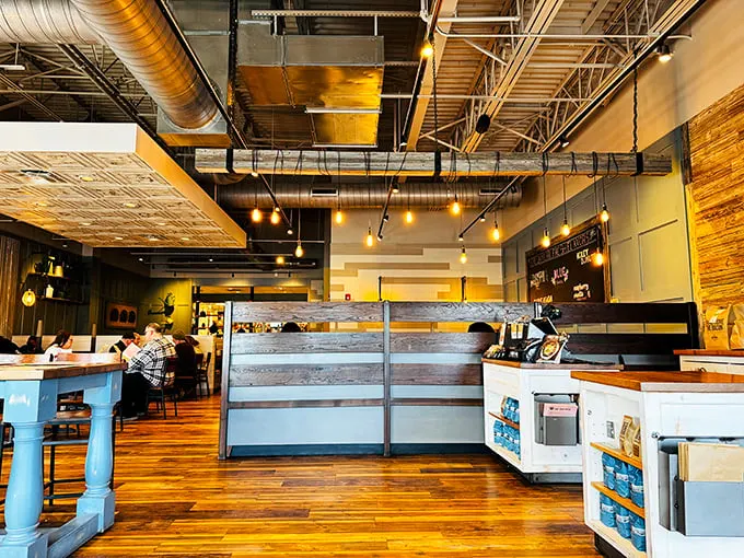 Industrial chic meets morning comfort in this warm, wood-filled interior. The exposed ceiling says "trendy" while the atmosphere whispers "come as you are."