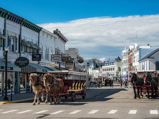 Horse-drawn carriages clip-clop down Mackinac Island's car-free streets. A Victorian time capsule where your phone is the only modern intrusion.
