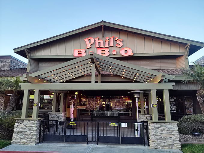 Phil's BBQ's lodge-like entrance beckons with the subtle glow of string lights—nature's way of saying "follow me to the ribs."