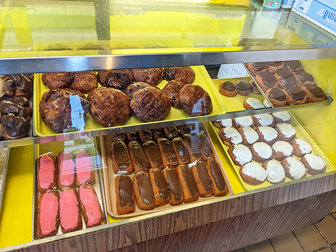 The display case—a museum of donut artistry where life's biggest decision becomes "glazed or chocolate?" Both is always the correct answer.