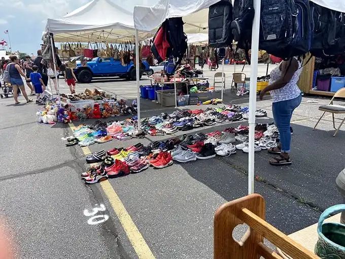 The outdoor market transforms asphalt into opportunity, with sneakers arranged like a colorful museum exhibit of footwear archaeology.
