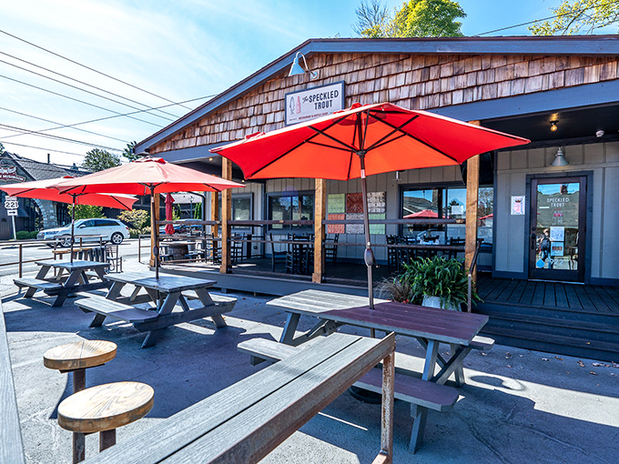 Nothing says "mountain hospitality" like picnic tables under bright red umbrellas. This outdoor dining setup promises conversations as fresh as the food.