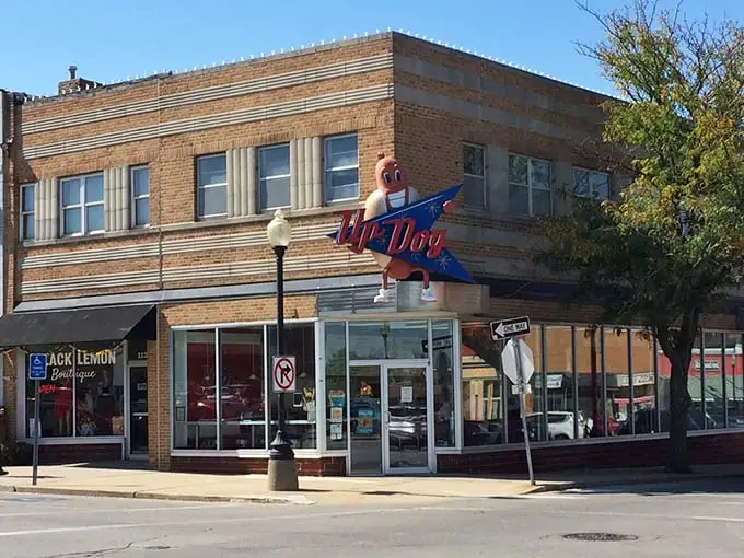 That vintage neon sign isn't just advertising—it's a beacon of hope for weary travelers seeking hot dog nirvana.
