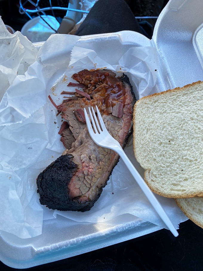 Behold the brisket in its natural habitat—bark-crusted, pink-ringed, and ready for its close-up. That slice has more character development than most Hollywood films.
