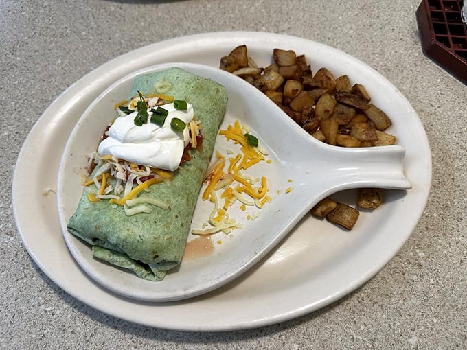 This isn't just a breakfast burrito—it's morning architecture with perfectly spiced potatoes, melted cheese, and a dollop of sour cream standing guard.