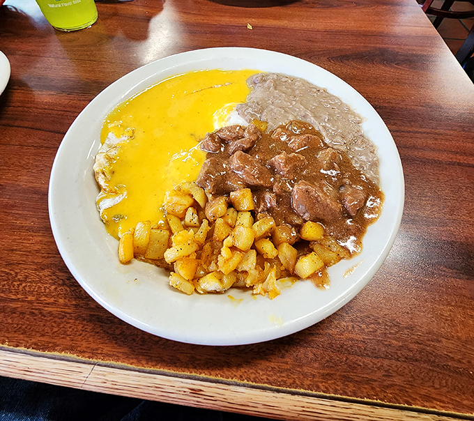 Eggs, potatoes, and refried beans create the holy trinity of Tex-Mex breakfast. This plate doesn't just feed you—it hugs your soul and high-fives your taste buds.