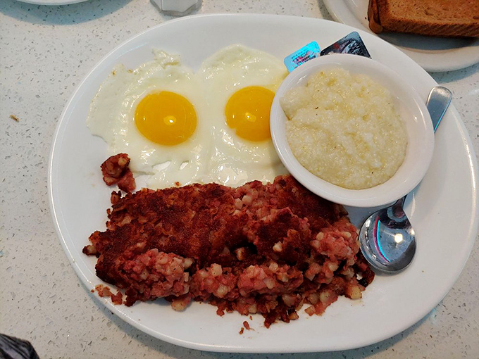 Corned beef hash with sunny-side-up eggs – where the yolks break with all the drama of a Florida sunset, creating a sauce that demands toast for dipping.