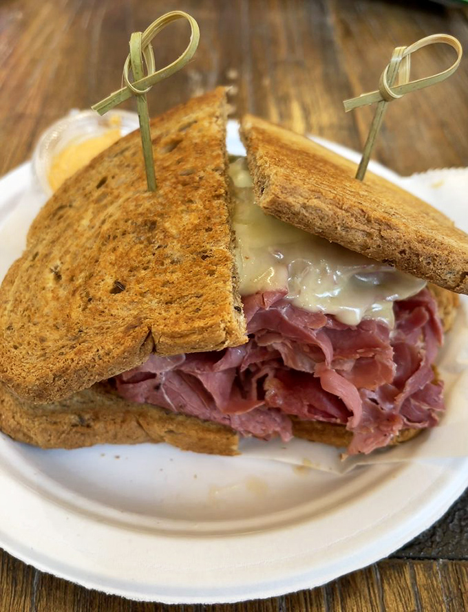 Behold the Reuben in its natural habitat—toasted rye, melted Swiss, and corned beef stacked higher than your weekend expectations.